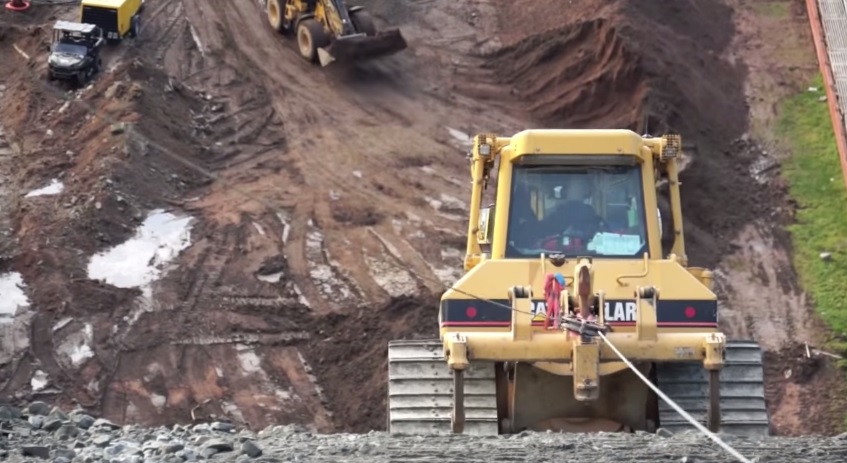 Bulldozer aan een staalkabel aan het werk op een helling van 40 graden.